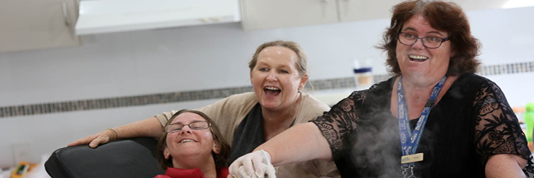 A woman with disability learning to cook with Northcott support workers - Northcott
