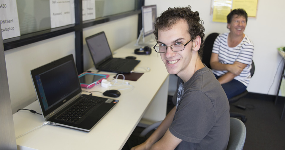 Raymond Clough sitting at a computer smiling while taking part in ...